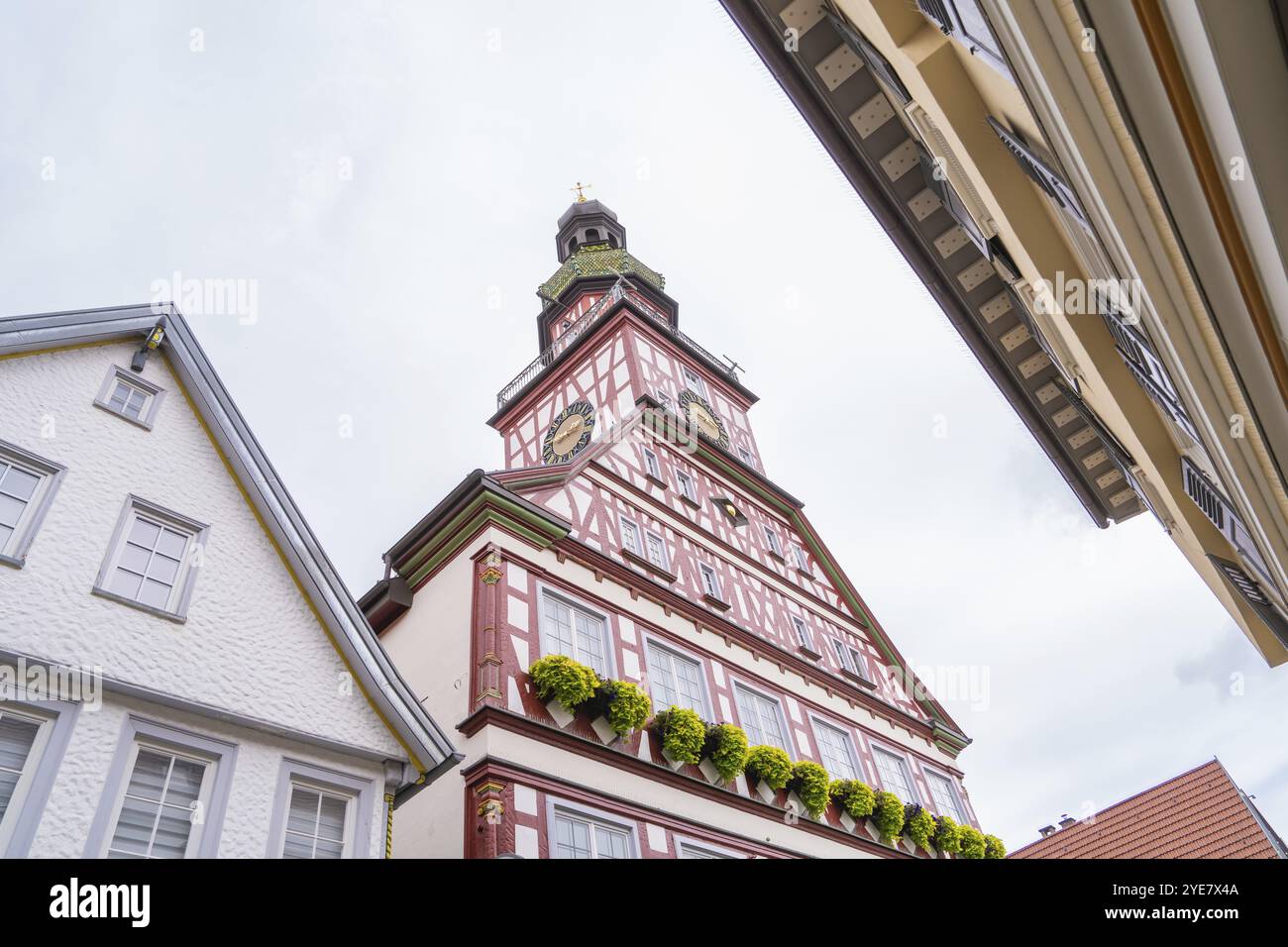 Half-timbered house with soaring church tower and ornate gables ...