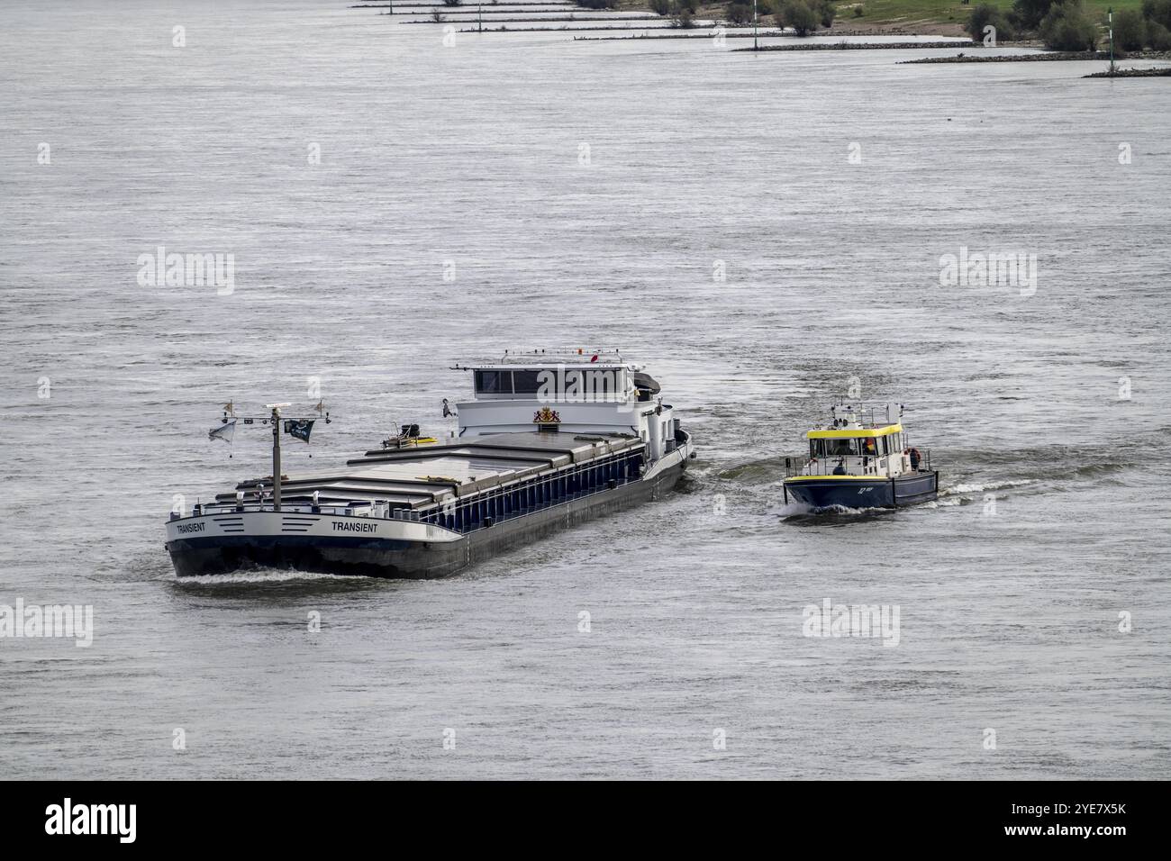 Water police boat sailing alongside a cargo ship on the Rhine near ...