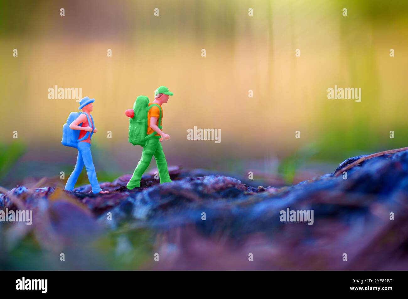Miniature figurines of hikers walking through a serene forest area ...