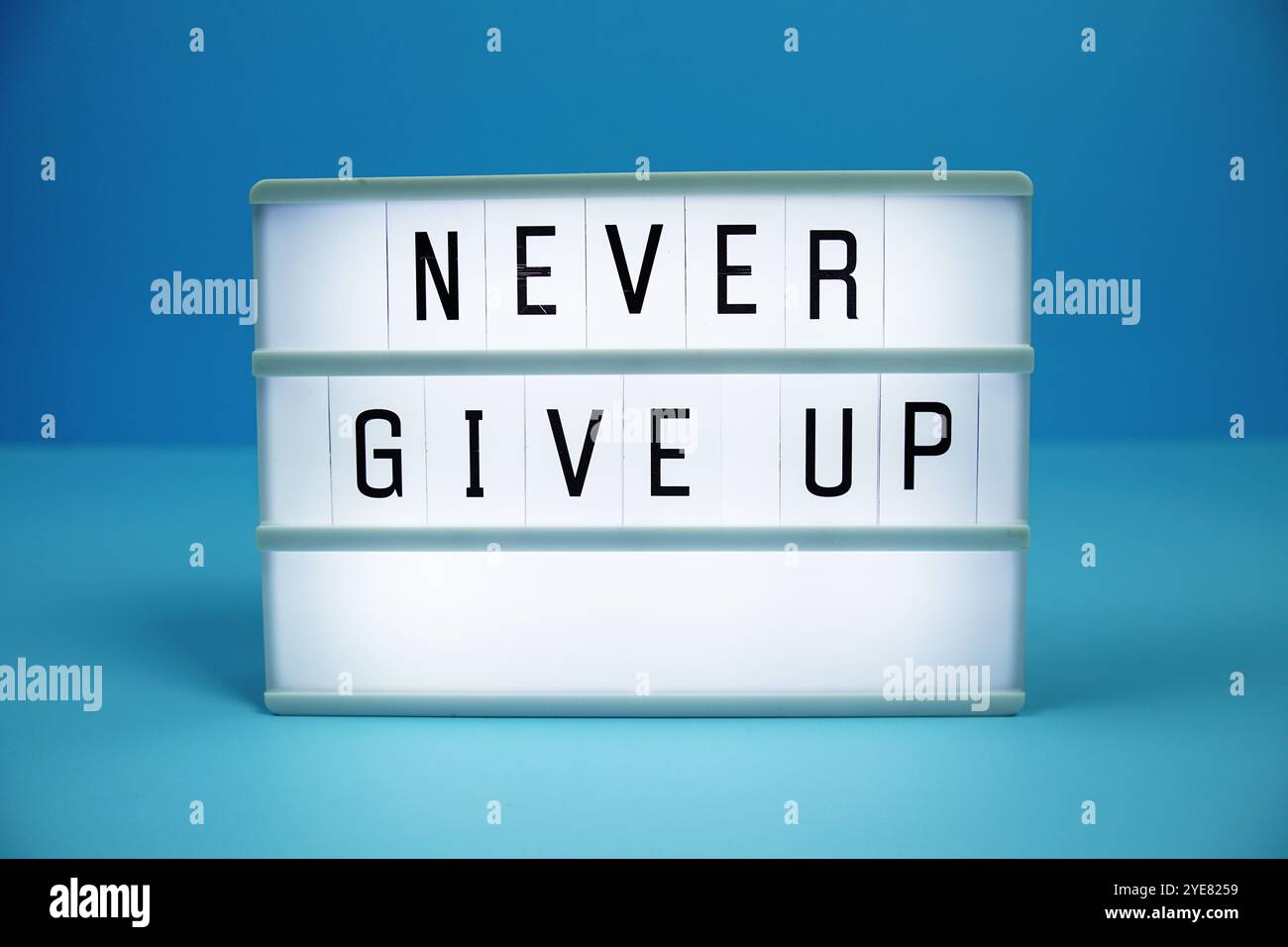 Never Give Up letterboard text on LED Lightbox on blue background Stock ...