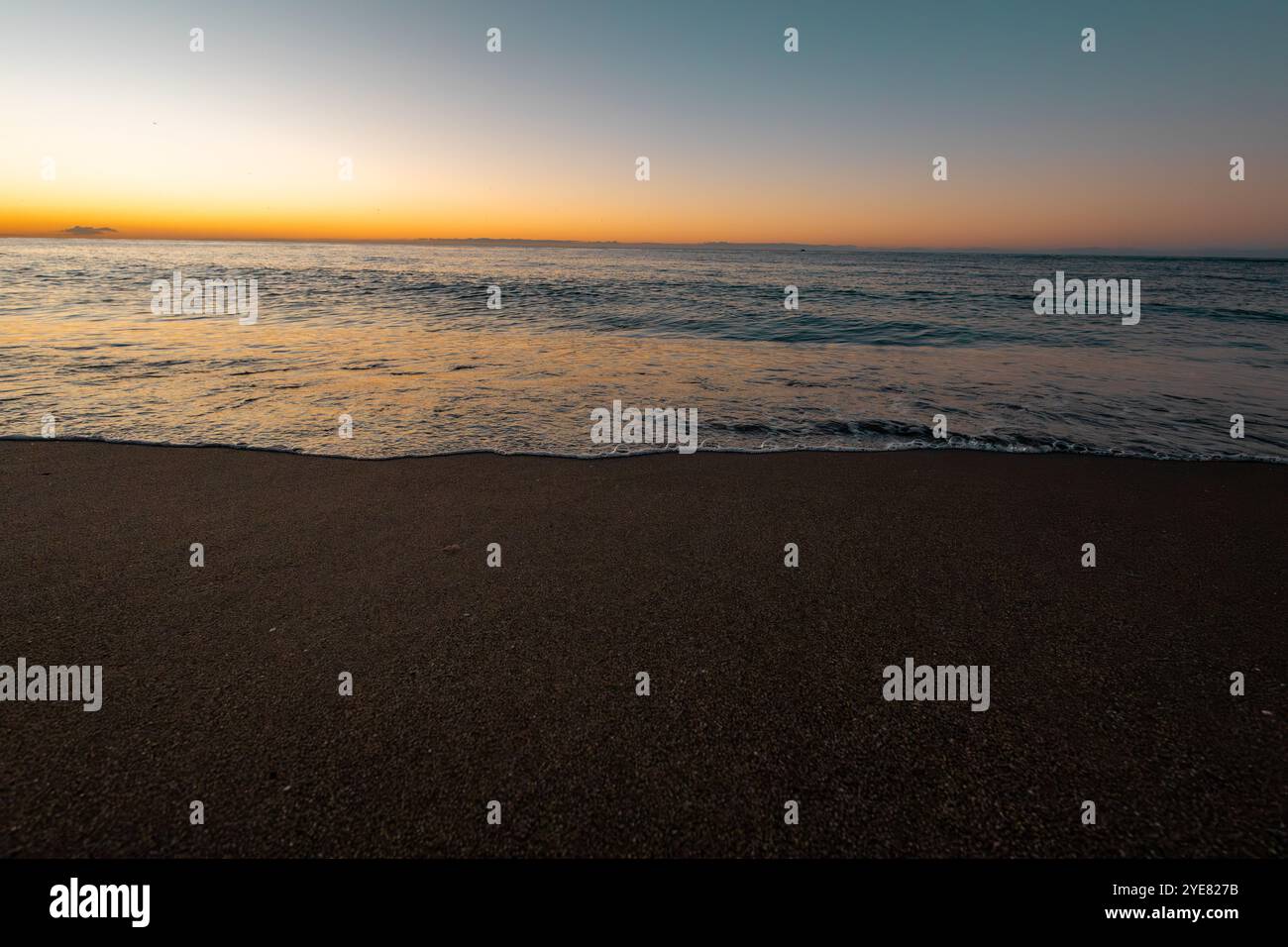 beautiful sunrise on the sea with white waves Stock Photo - Alamy