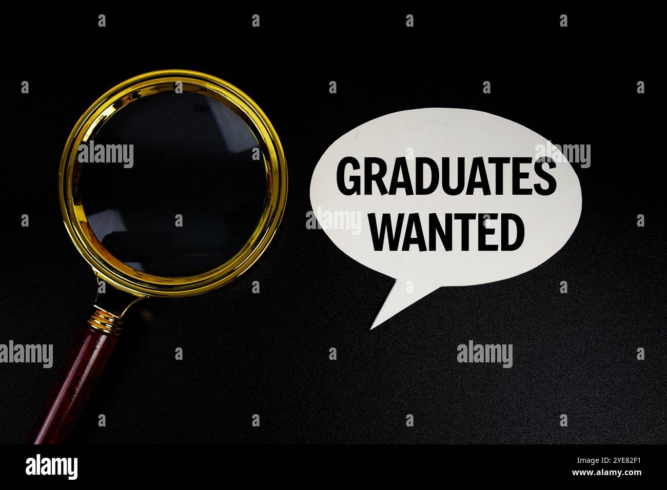 Graduates wanted text on speech bubble with magnifying glass top view ...