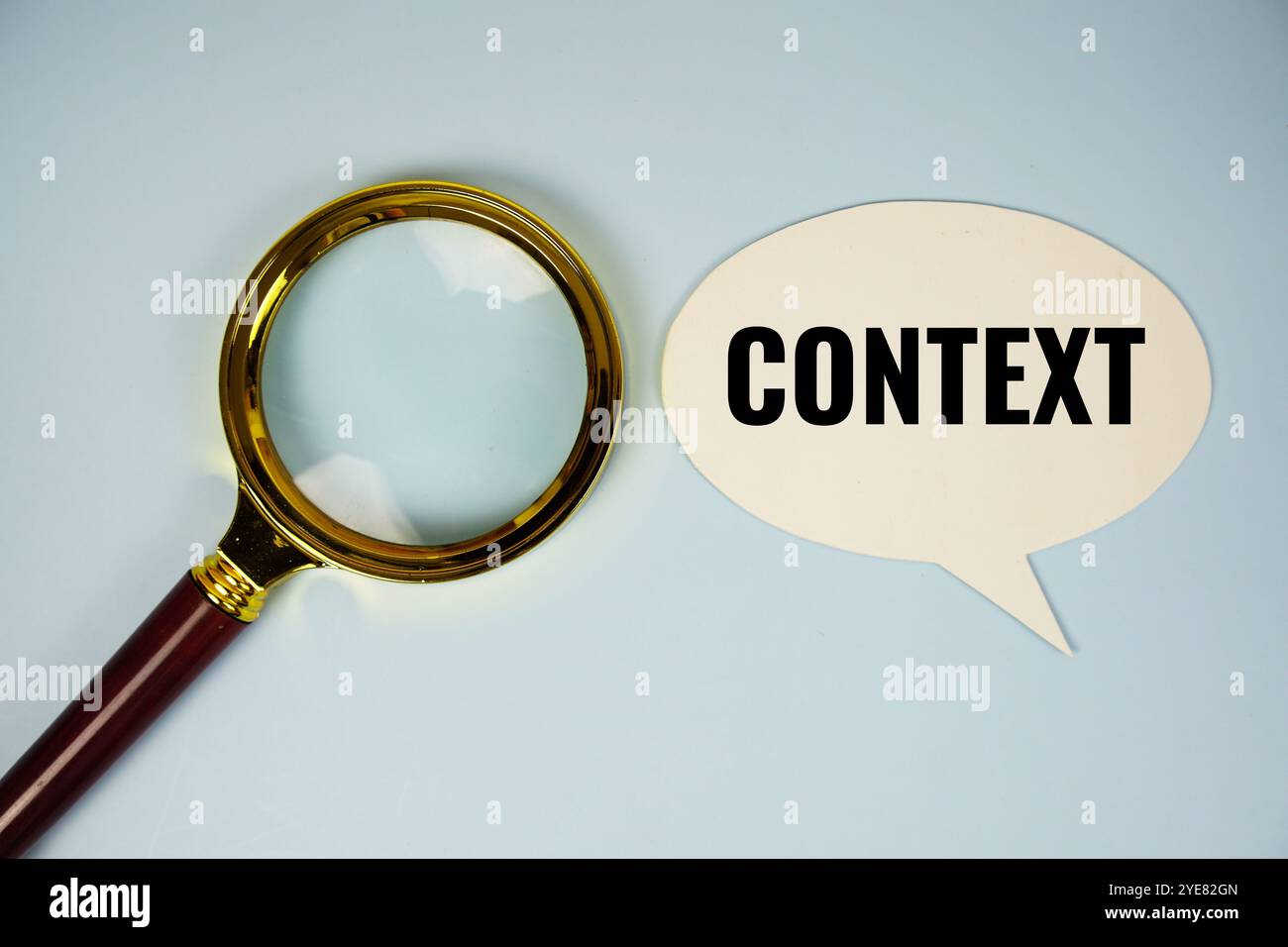 Context text on speech bluble with magnifying glass top view on blue ...