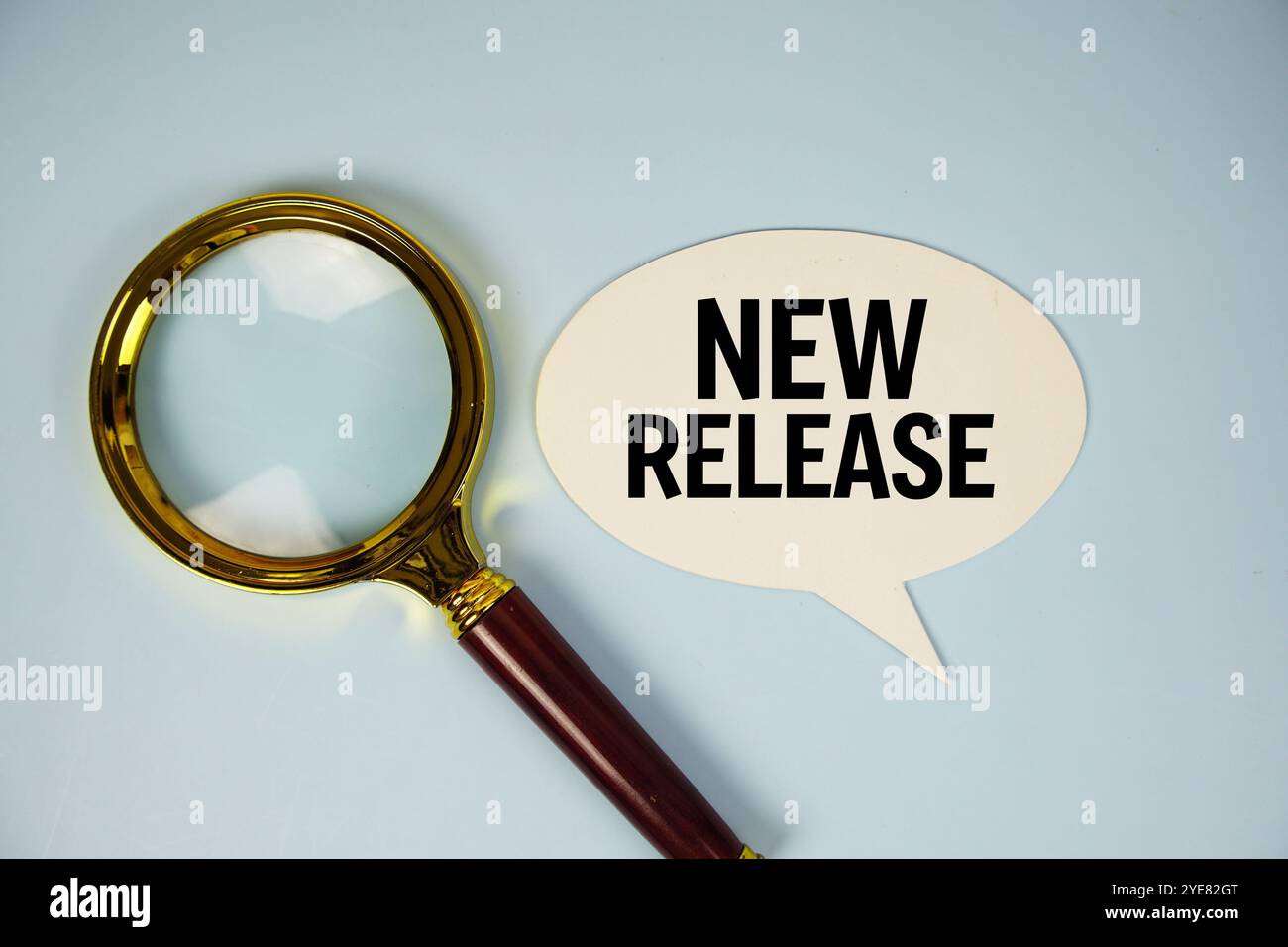 New Release text on speech bluble with magnifying glass top view on ...