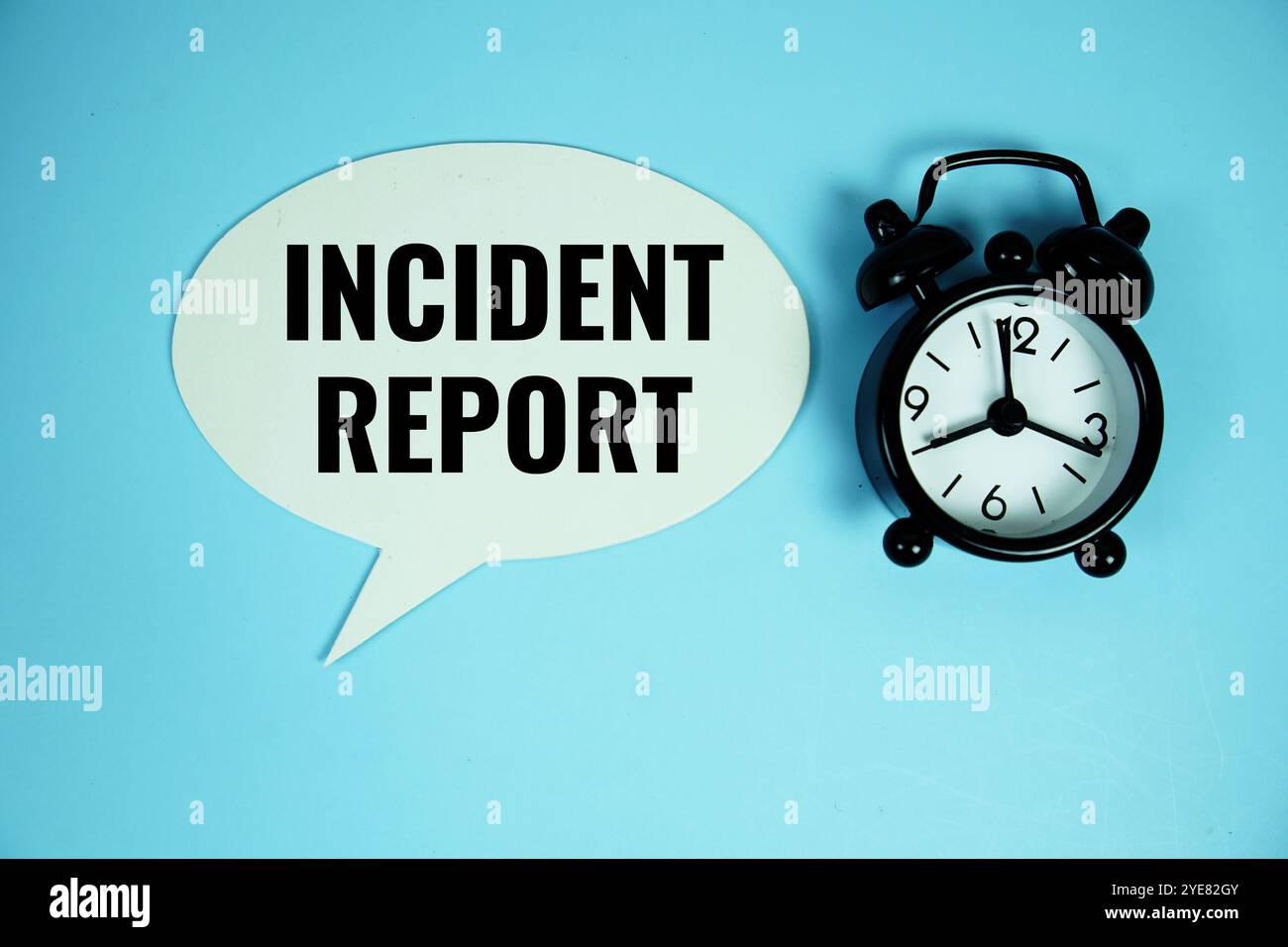Incident Report text on speech bluble with alarm clock top view on blue ...