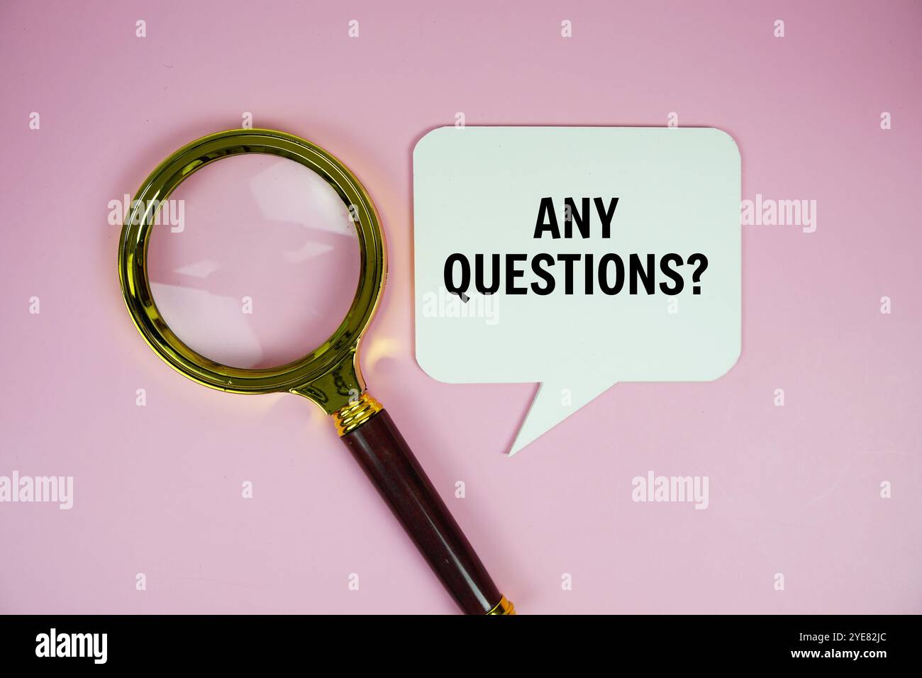 Any Questions? text on speech bluble with magnifying glass top view on ...