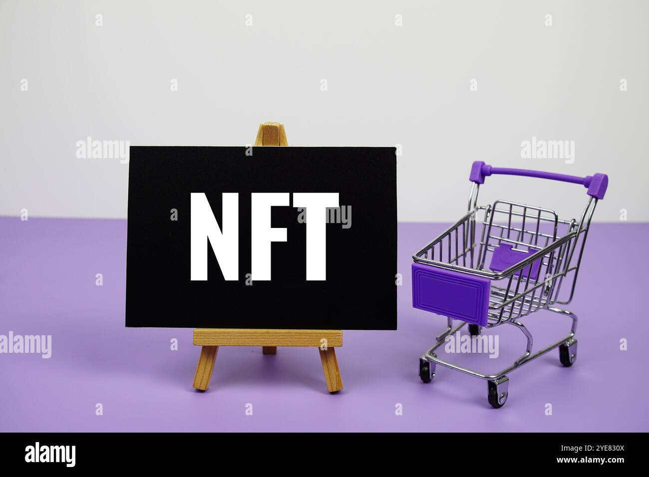 NFT text message and trolley shopping cart on purple background Stock ...