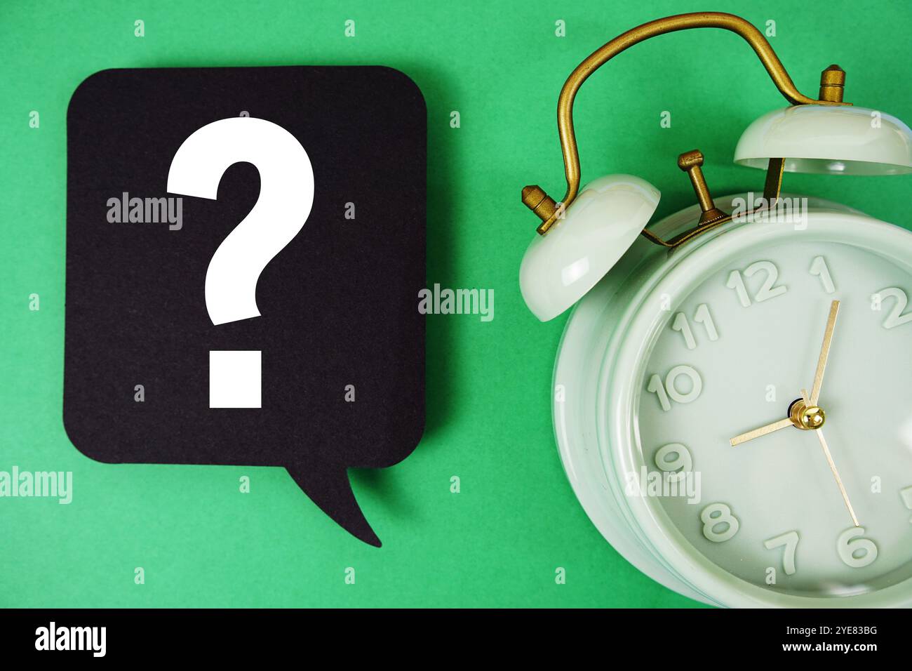 Question mark text on speech bubble with alarm clock on green ...