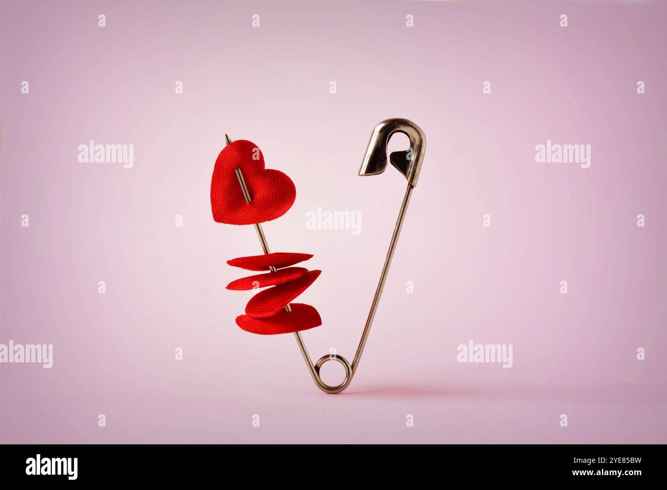 Safety pin with hearts on pink background - Concept of love Stock Photo ...