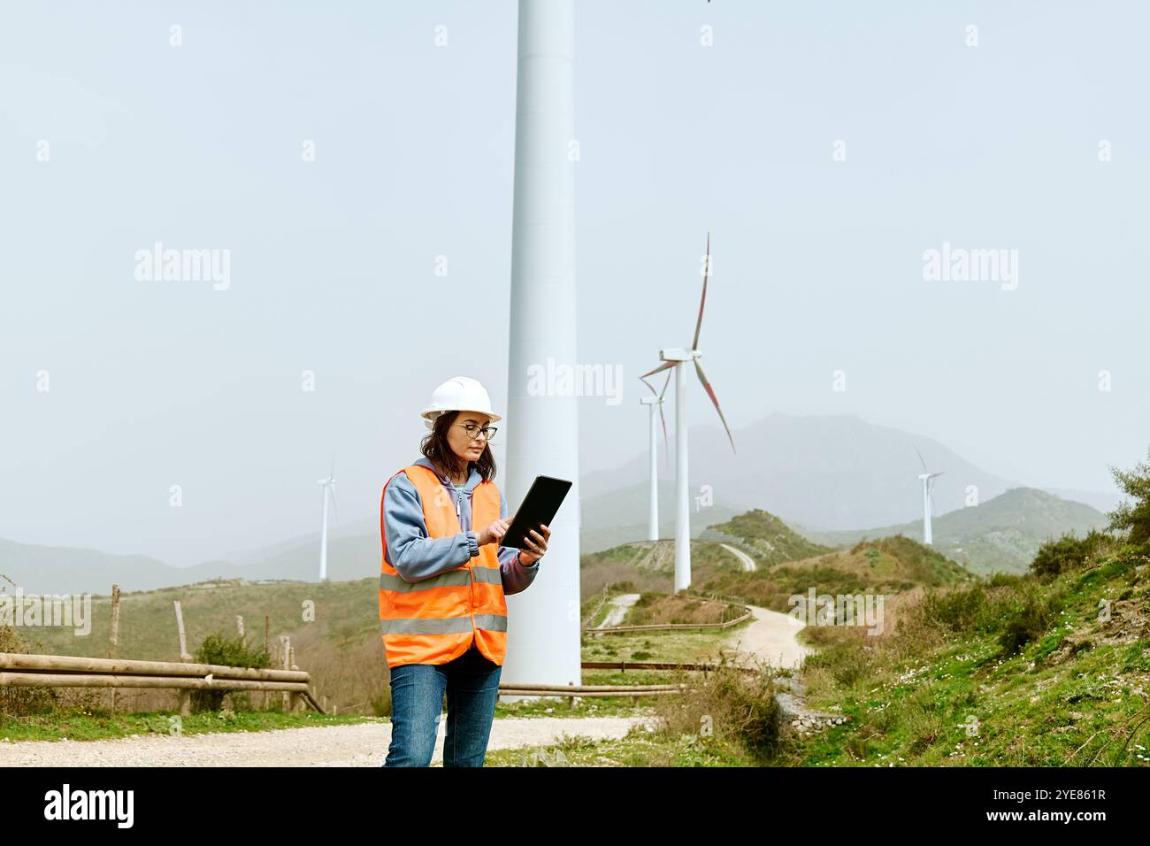 Female engineer wearing a helmet and protective clothes with digital ...