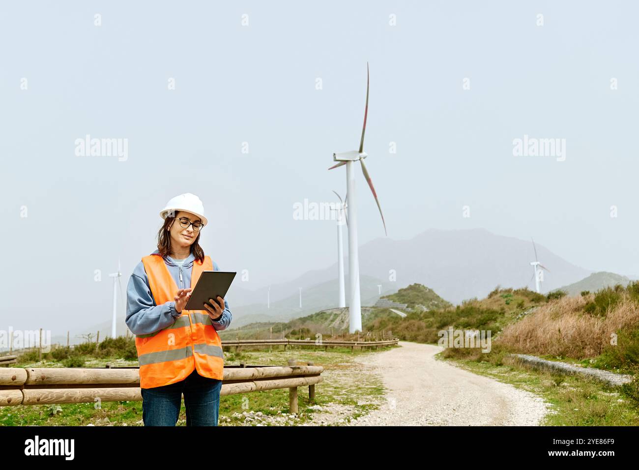 Female engineer wearing a helmet and protective clothes with digital ...