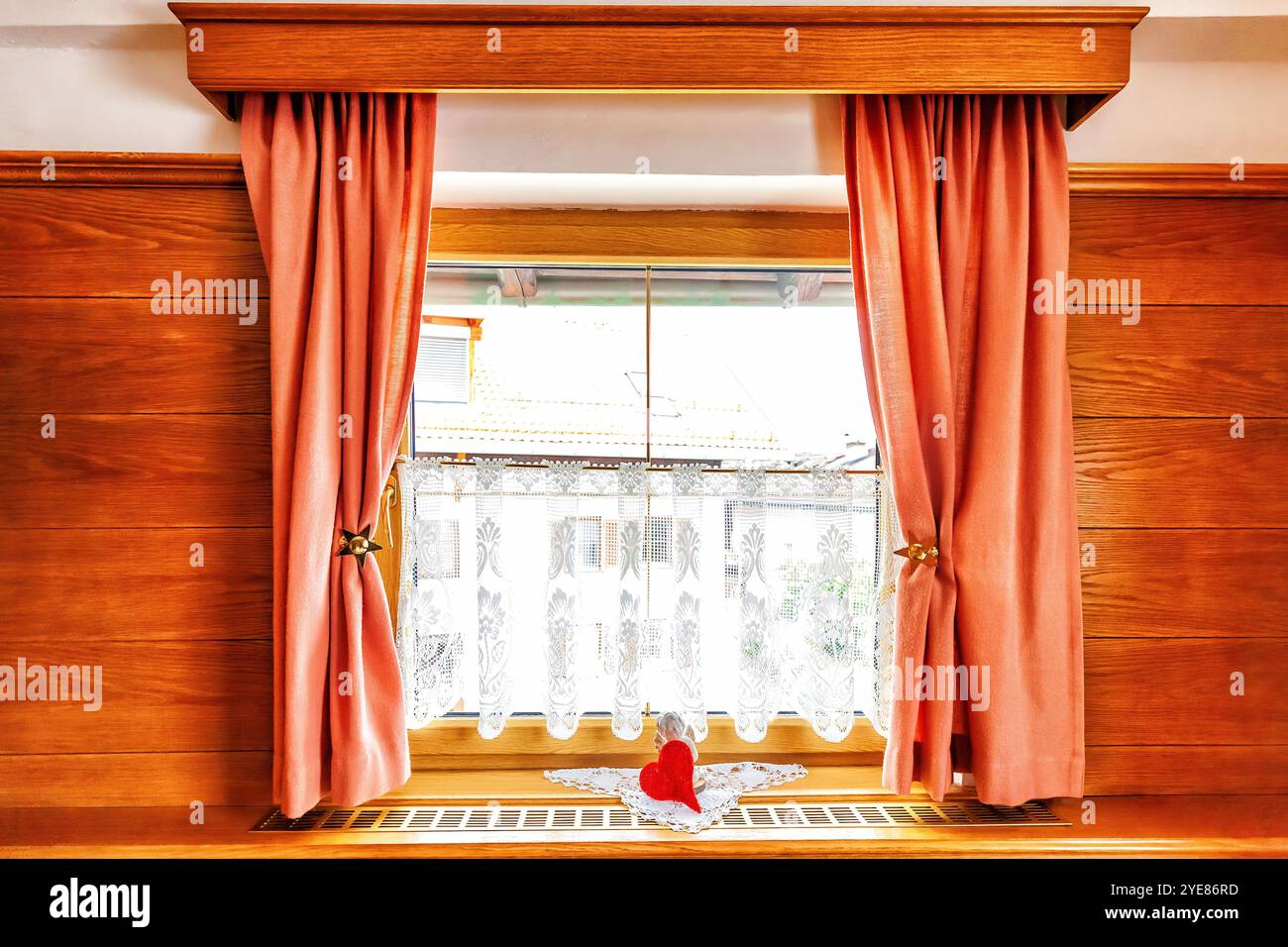 Wooden window with short pink pinch pleat curtains and lacy curtain in ...