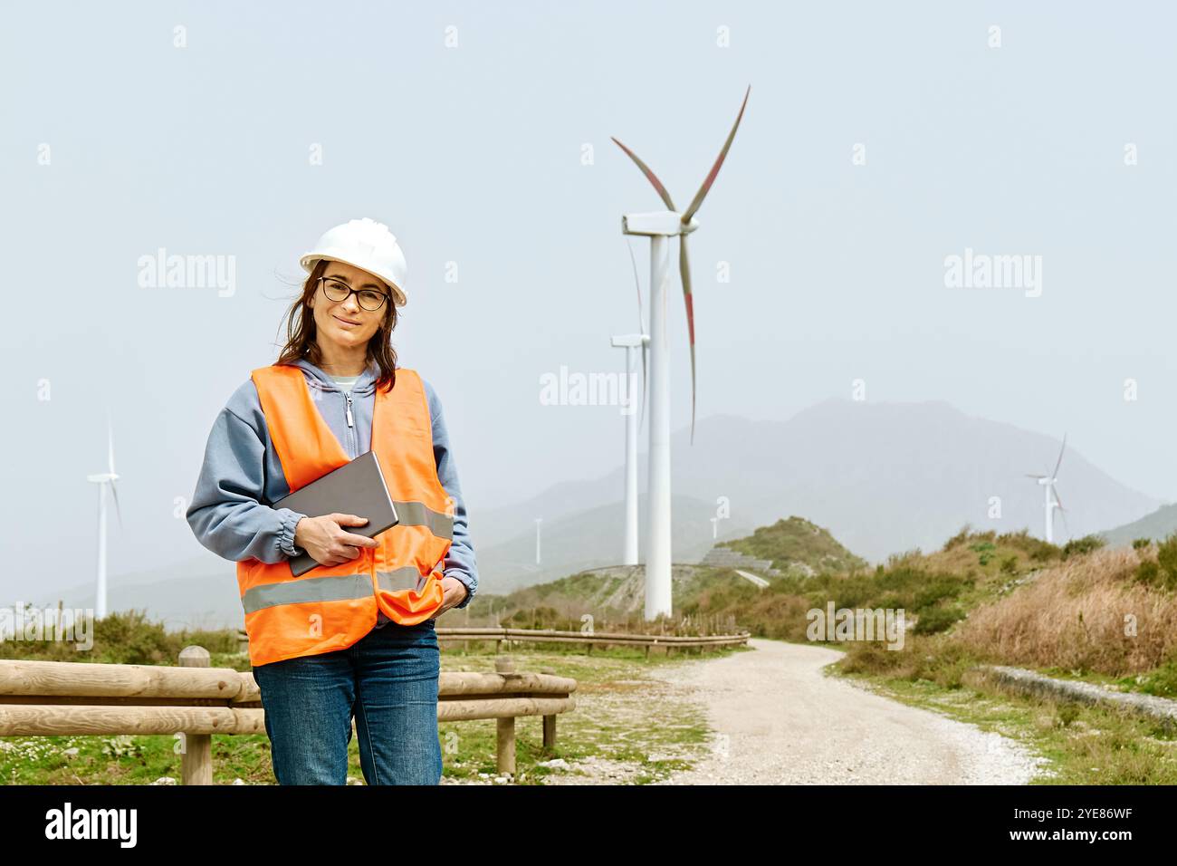 Female engineer wearing a helmet and protective clothes with digital ...