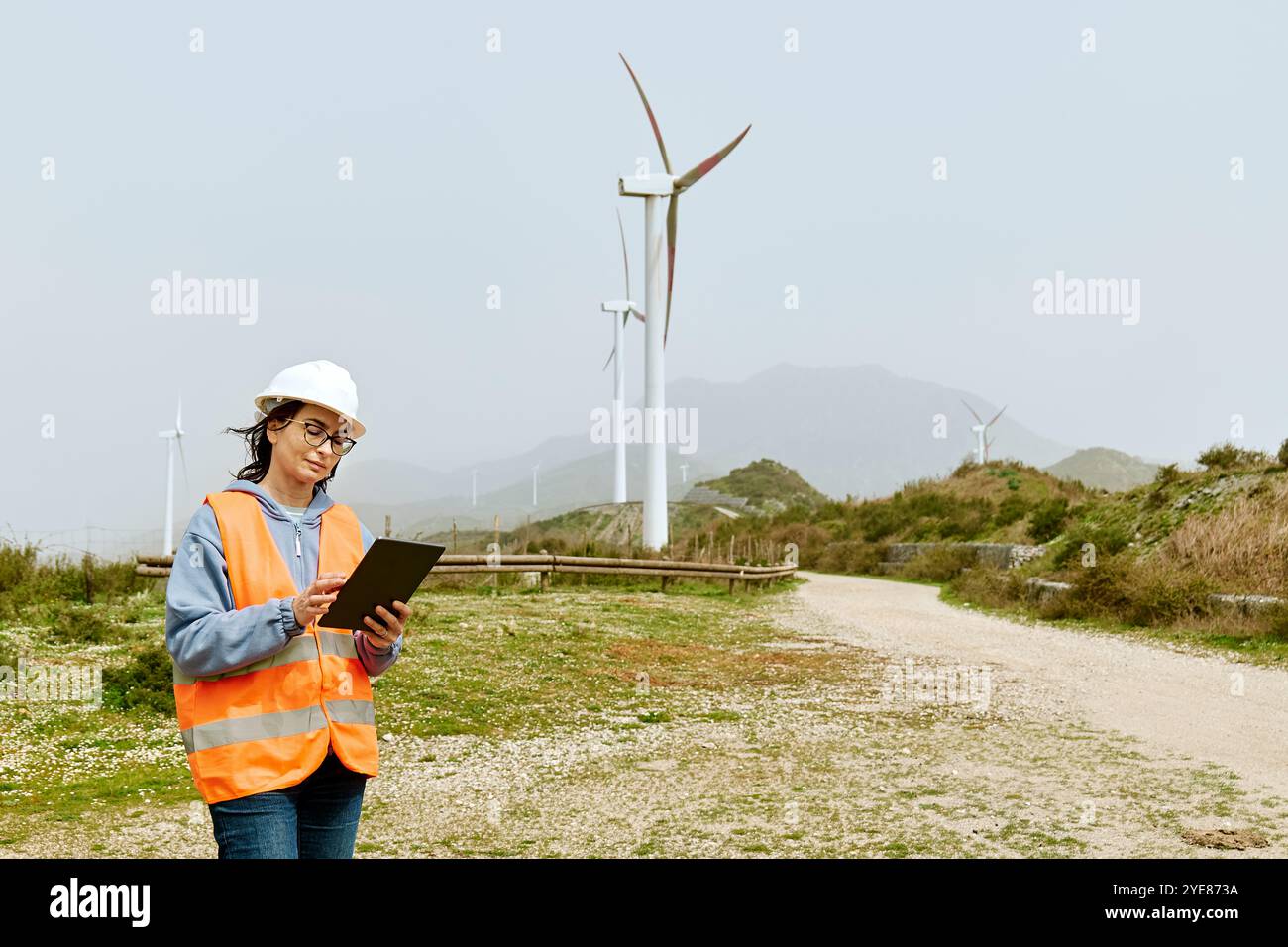 Female engineer wearing a helmet and protective clothes with digital ...