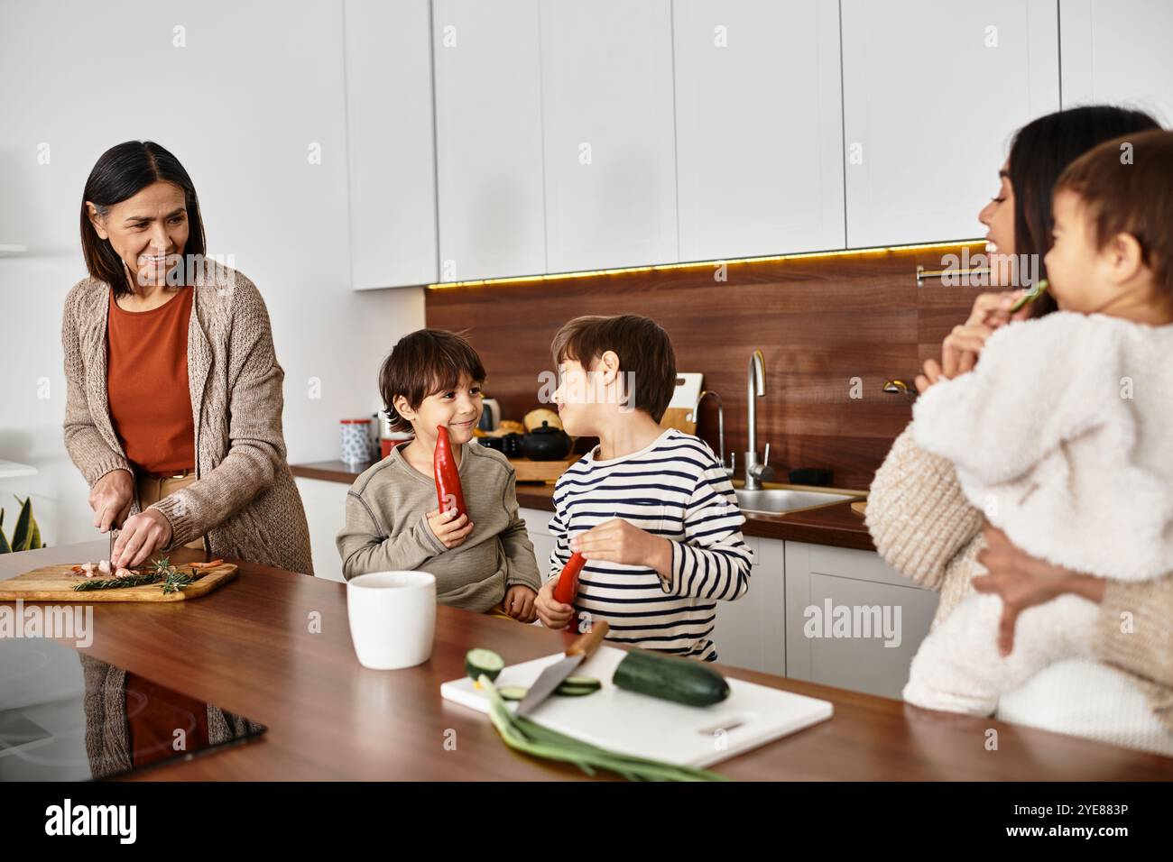A happy Asian family enjoys cooking festive treats together in their ...