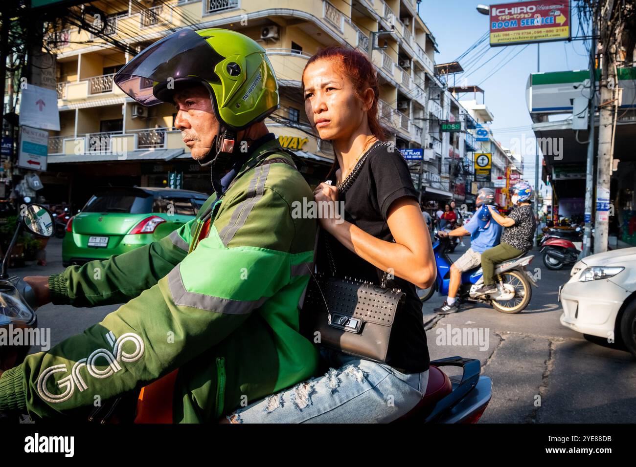 A young Thai lady gets a lift from a Grab driver along Soi Buakhao ...