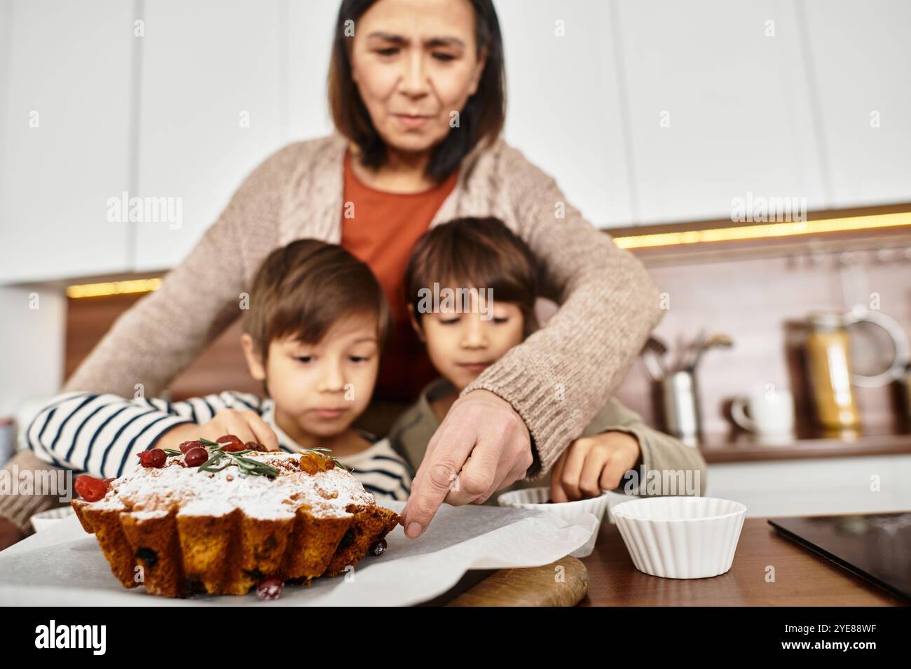 An Asian family enjoys baking delicious pastries together in their ...