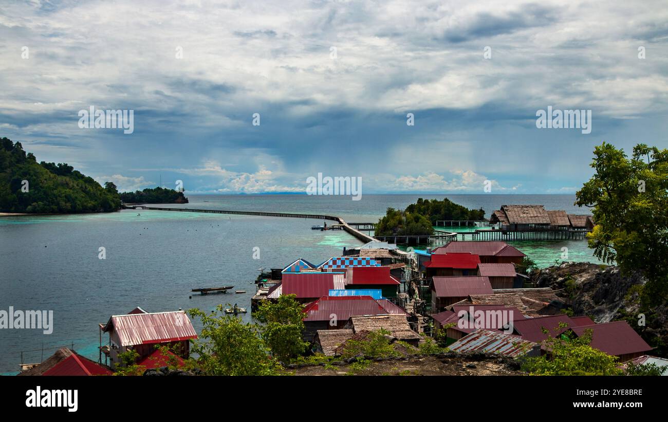 overlooking a small village on water with a long bridge between islands ...