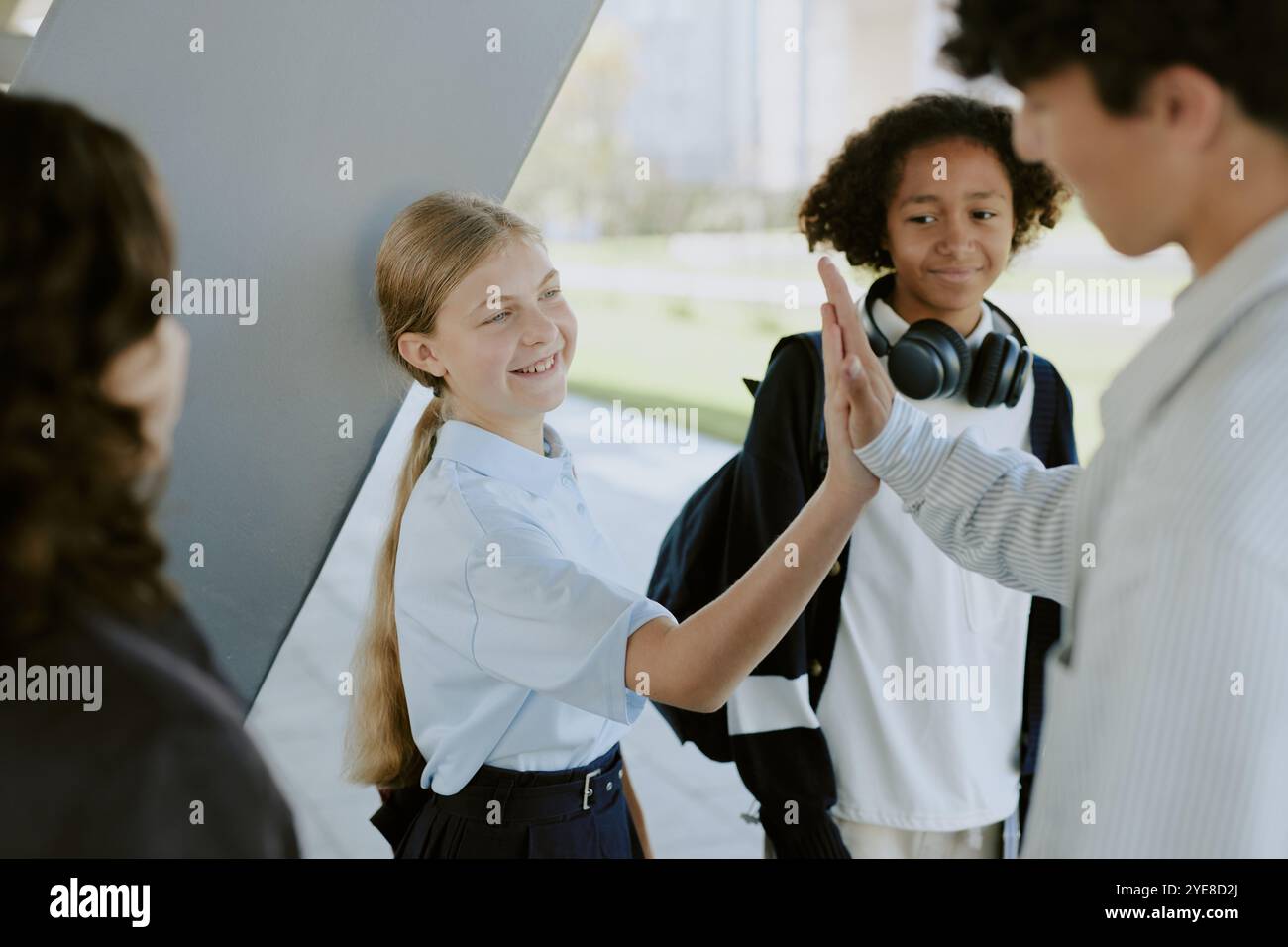Biracial kids highing five while walking together after long school day ...