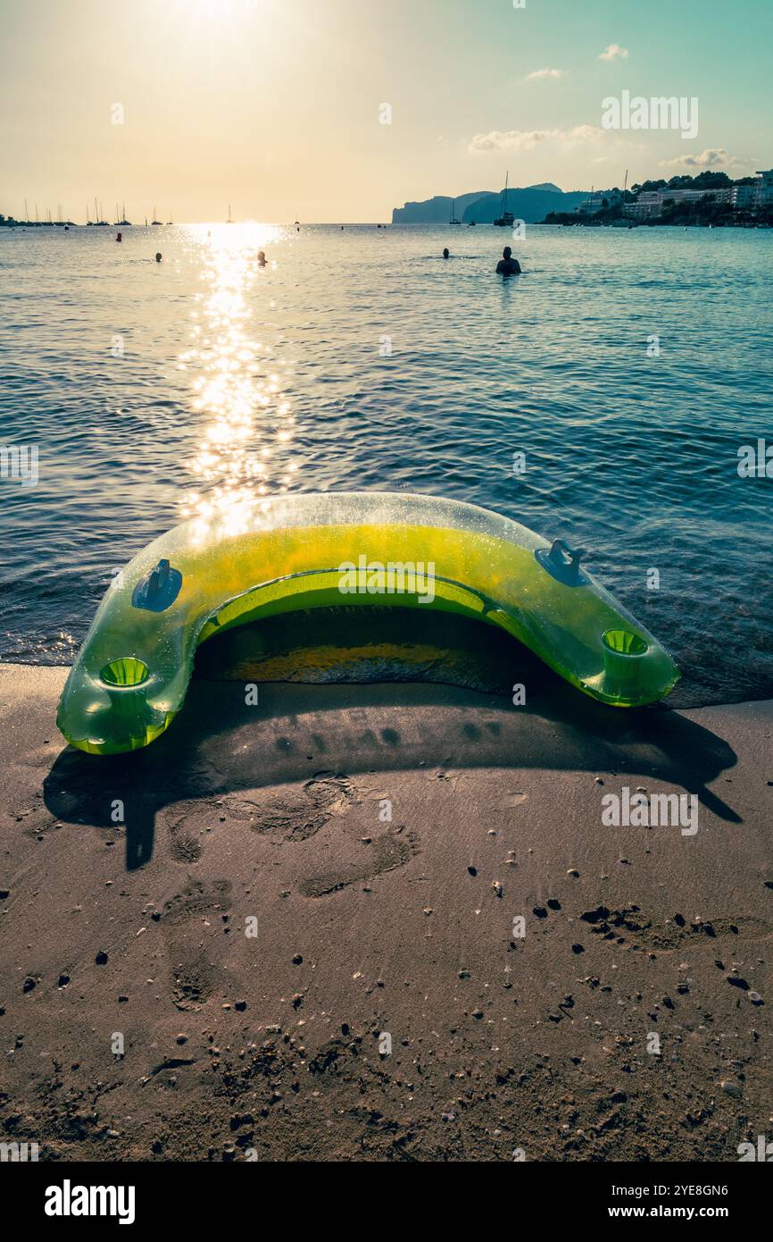 Inflatable on sunsetting beach Stock Photo - Alamy