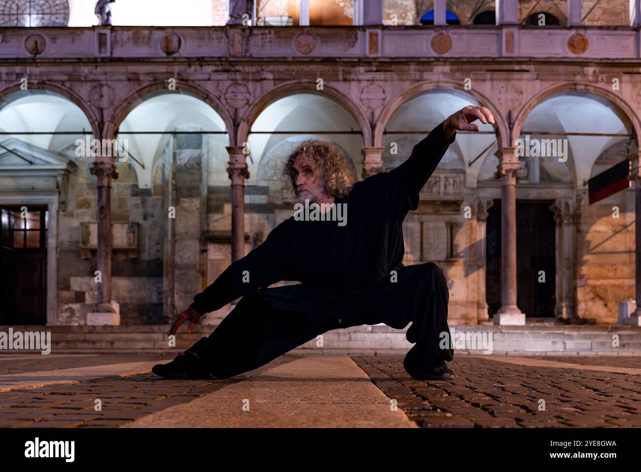 middle aged tai chi master showing stick exercises outdoors amidst the ...
