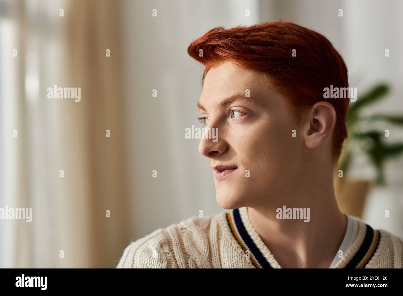 The young man with fiery red hair reflects warmly in a serene setting ...