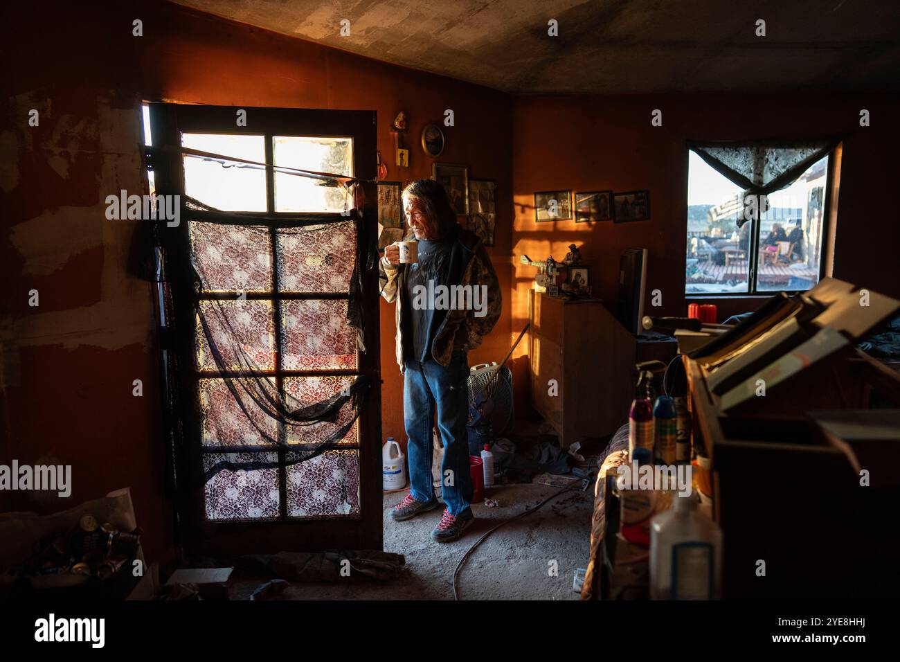 Navajo Felix Ashley drinks coffee while standing inside his home, on ...