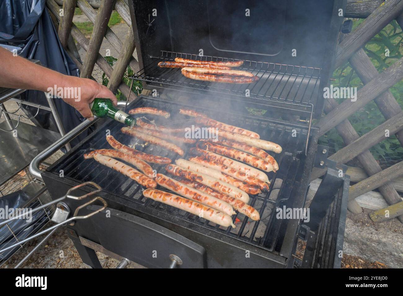 Bratwurst auf dem Grill, ablöschen mit Bier *** Bratwurst on the grill ...
