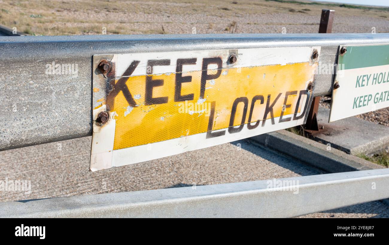 Metal Gate on the beach at Dungeness with a large yellow keep locked ...