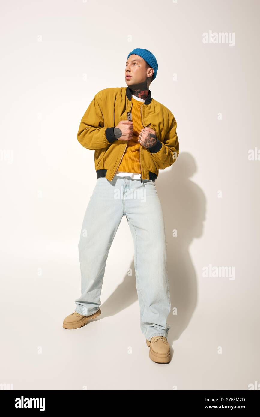 A young man showcases his tattoos while striking a bold pose in trendy ...