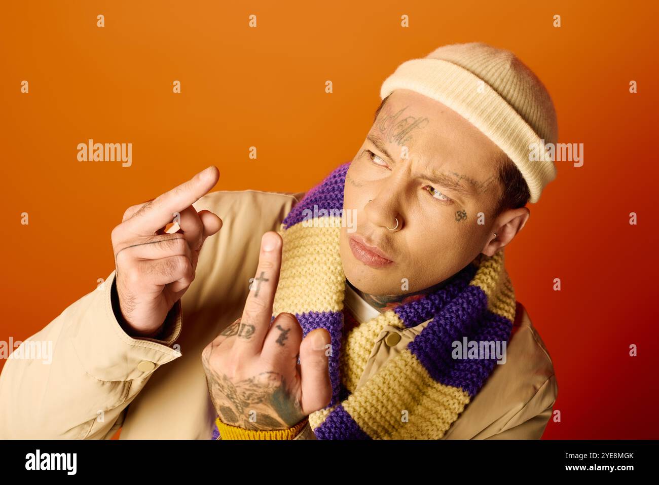 A young man with unique tattoos displays intriguing hand gestures while ...