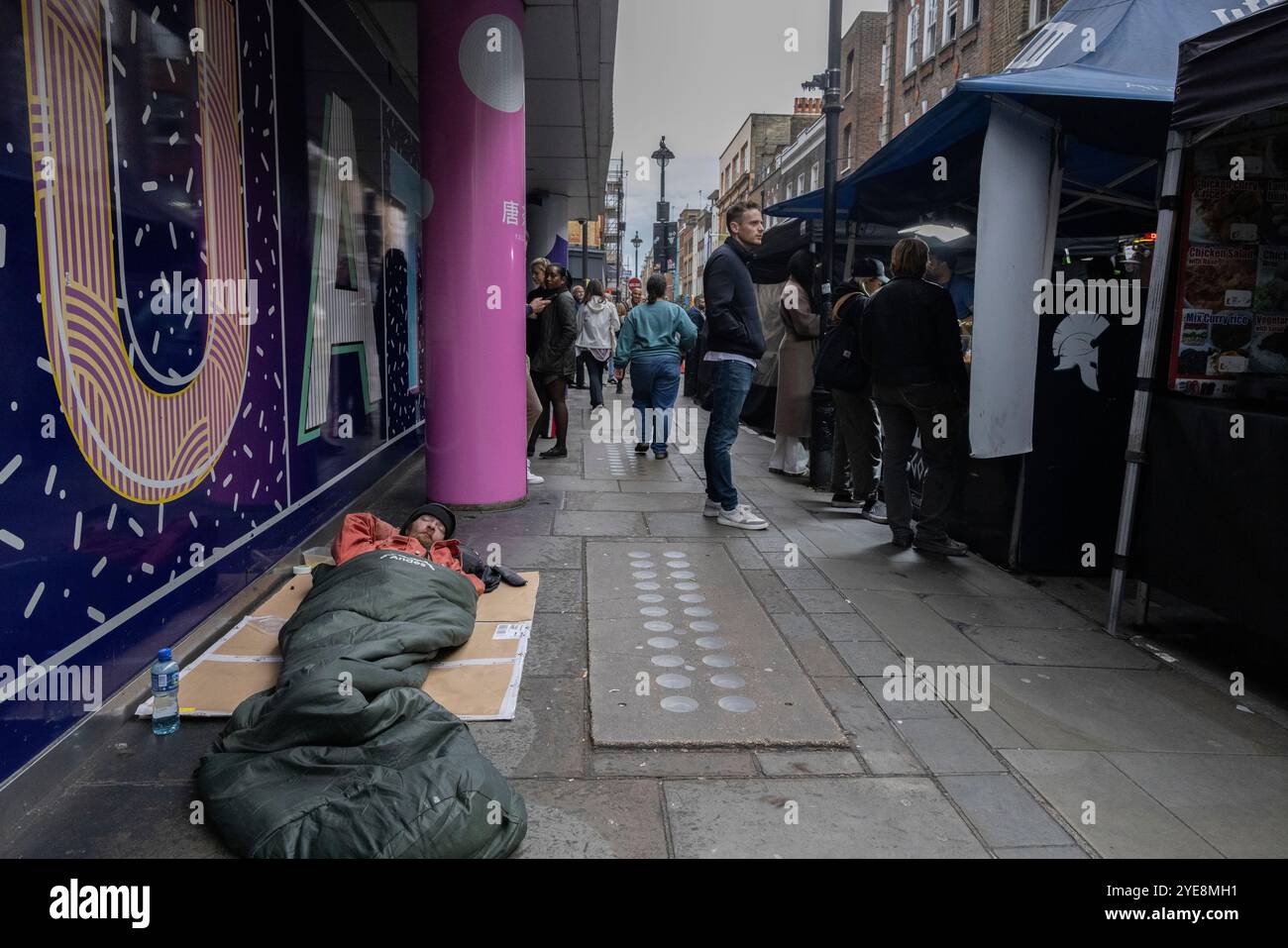 A homeless man lies in his sleeping bag on the pavement along Berwick ...