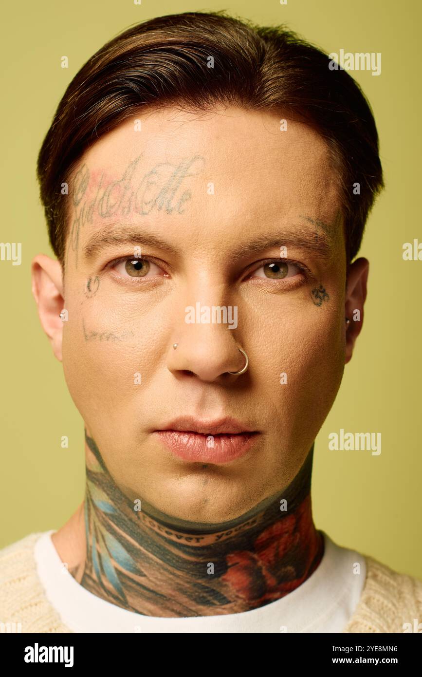 The young man showcases intricate tattoos on his face and neck while ...