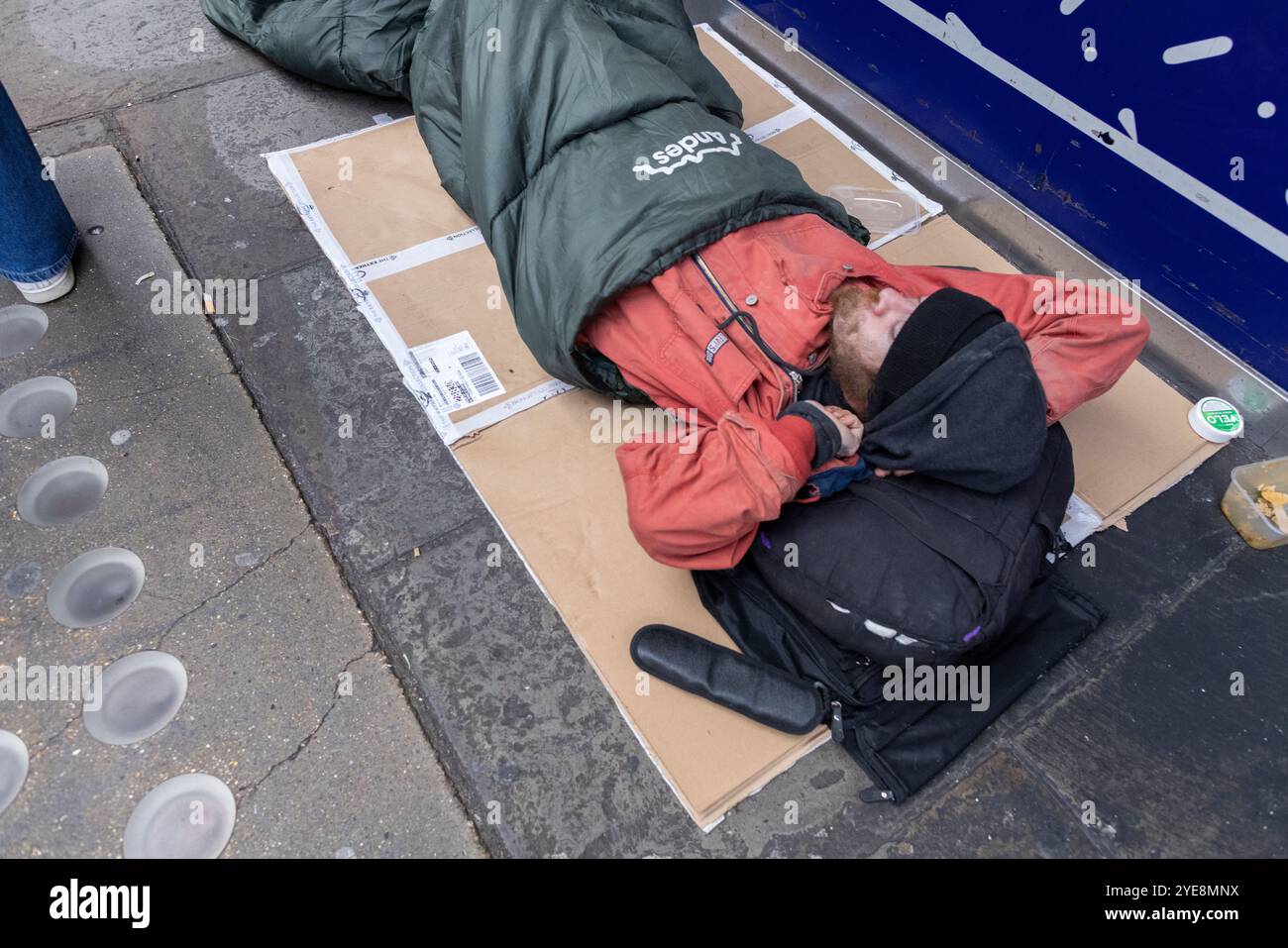 A homeless man lies in his sleeping bag on the pavement along Berwick ...