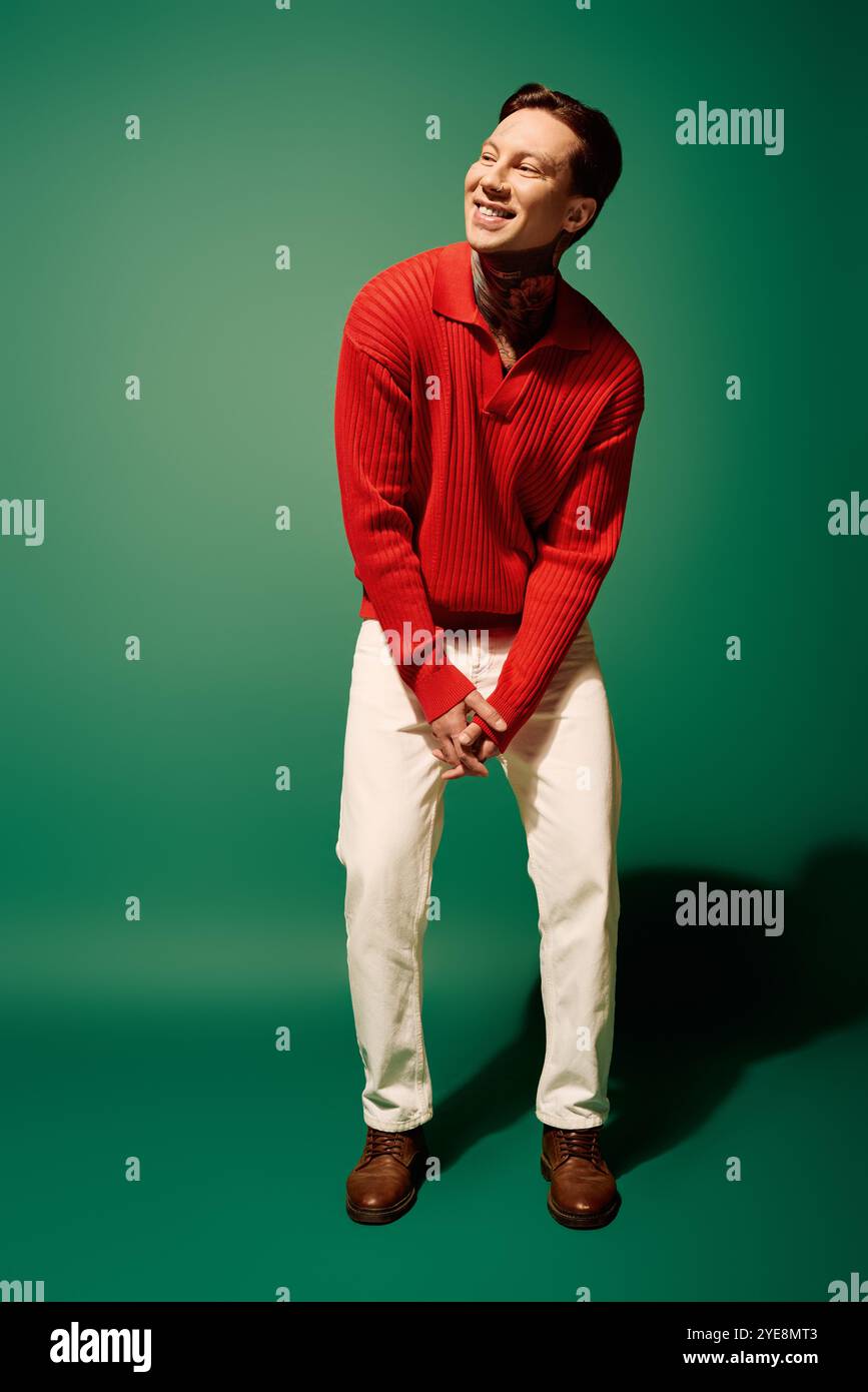 The young man smiles brightly while standing playfully in a striking ...