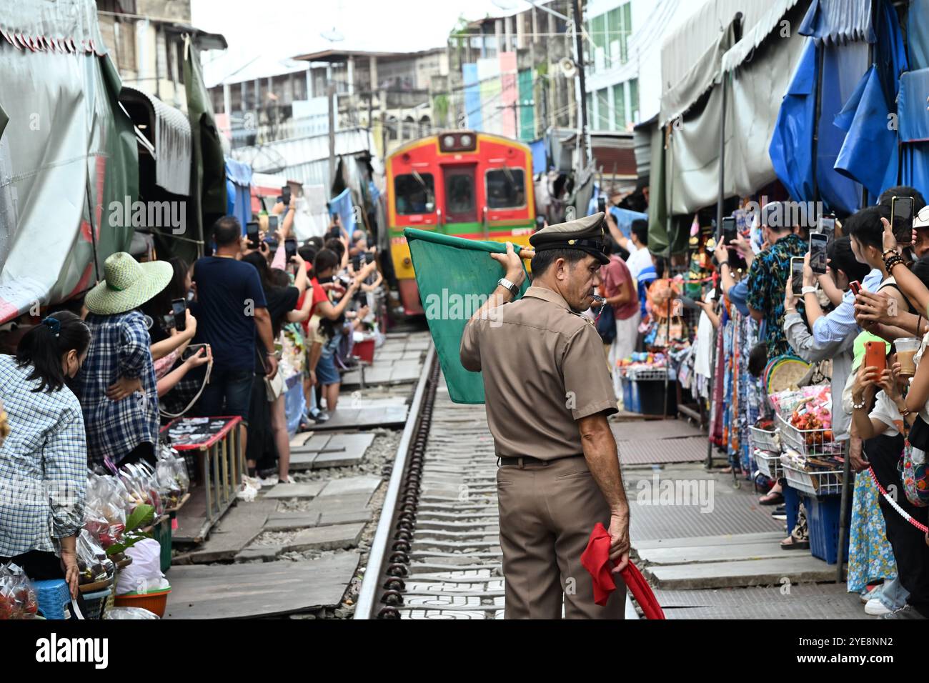 Railway market Thailand ,Station Master signals train by waving red and ...