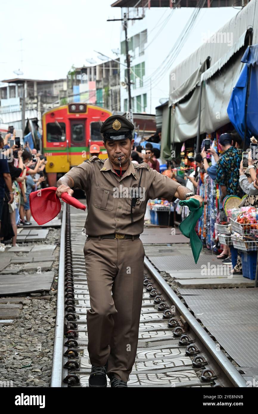 Railway market Thailand ,Station Master signals train by waving red and ...
