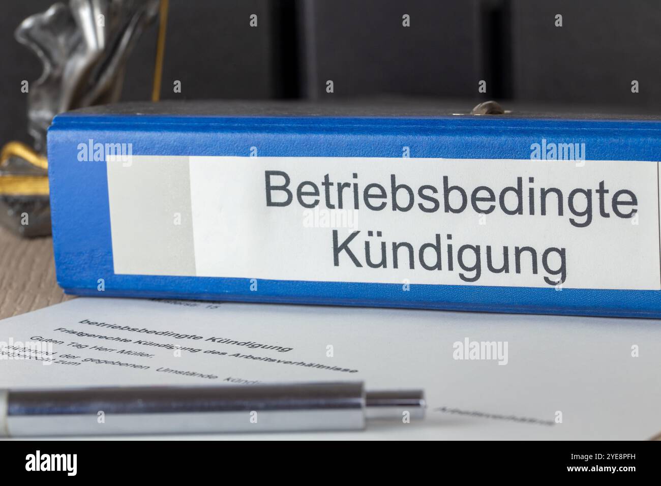 Notice of termination in front of a folder labelled BETRIEBSBEDINGTE ...