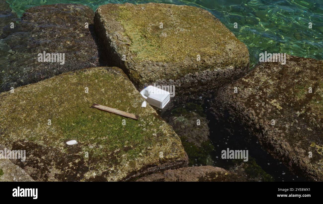 Trash contamination on large rocks by the pristine coastline of ...