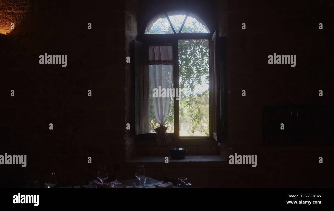 A quaint and rustic indoor scene featuring a partially open window with ...