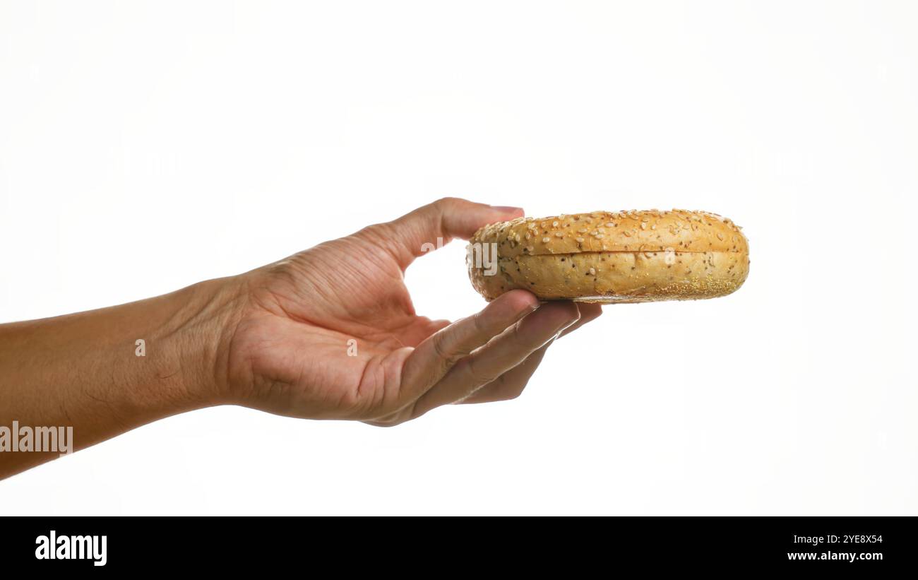 Hand holding a seeded bagel over an isolated white background Stock ...