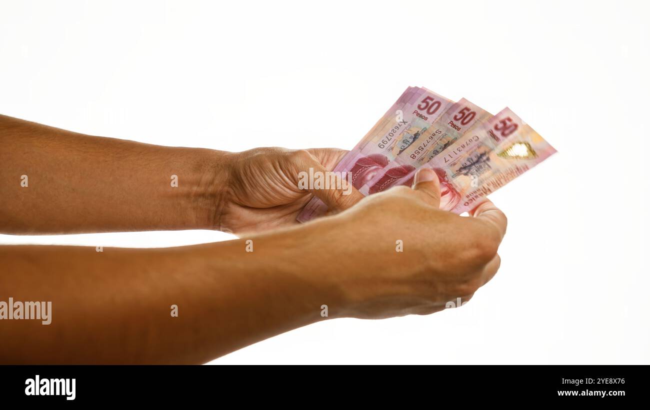 Hands holding mexican pesos over a white isolated background showcasing ...