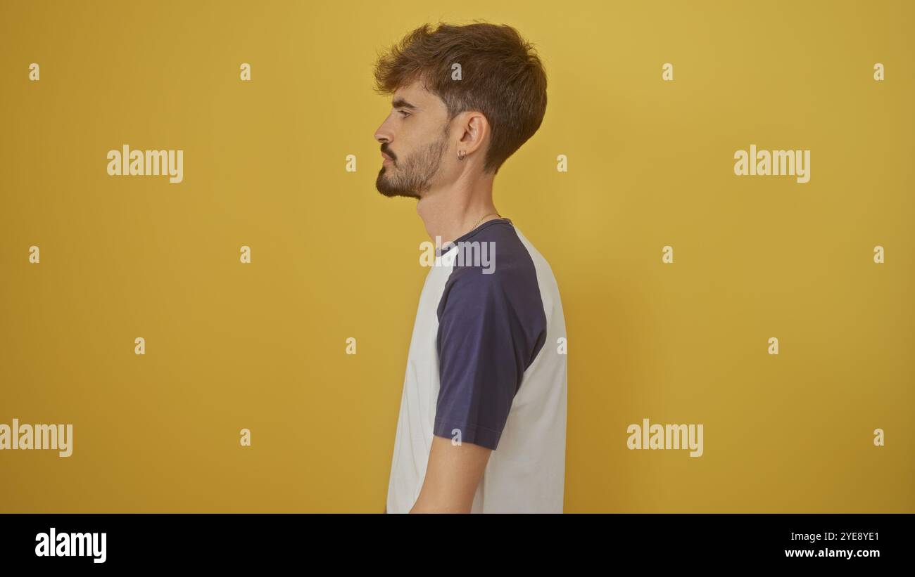 Side profile of a young hispanic man with a beard standing against a ...