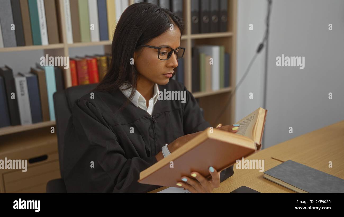 Woman reading book wearing judge robes in office with bookshelves in ...