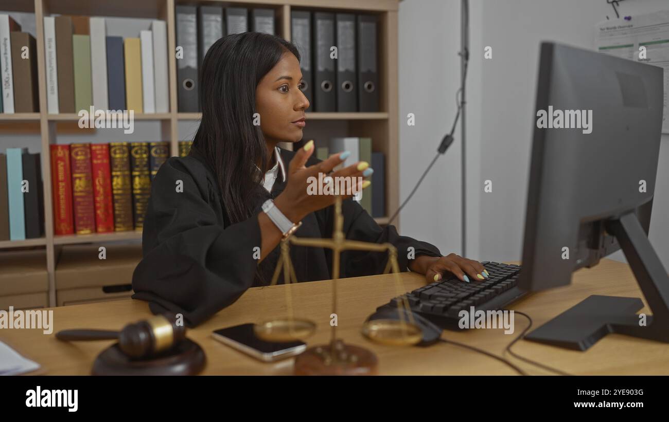 Woman judge in office wearing black robes working at computer with law ...