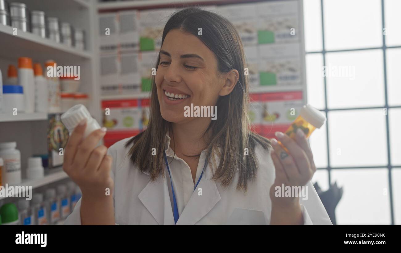 A smiling young brunette woman pharmacist holds medicine bottles inside ...
