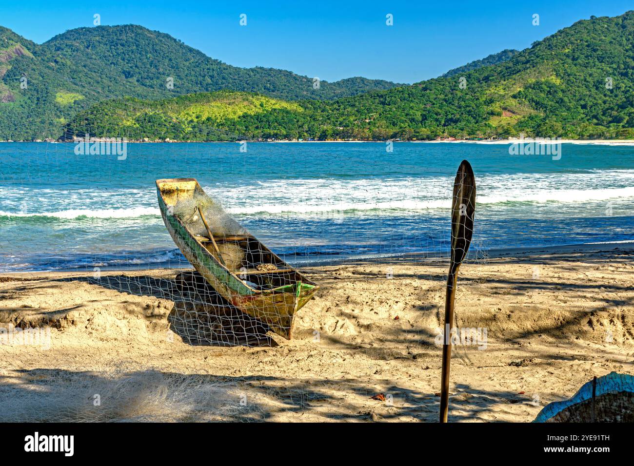 Canoe and fishing net on Castelhanos beach on Ilhabela island in Sao ...