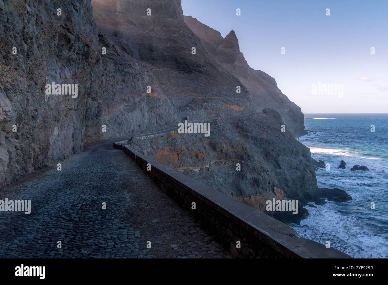 The scenic road to Ponta do Sol, with the rocky cliffs, paved way and ...