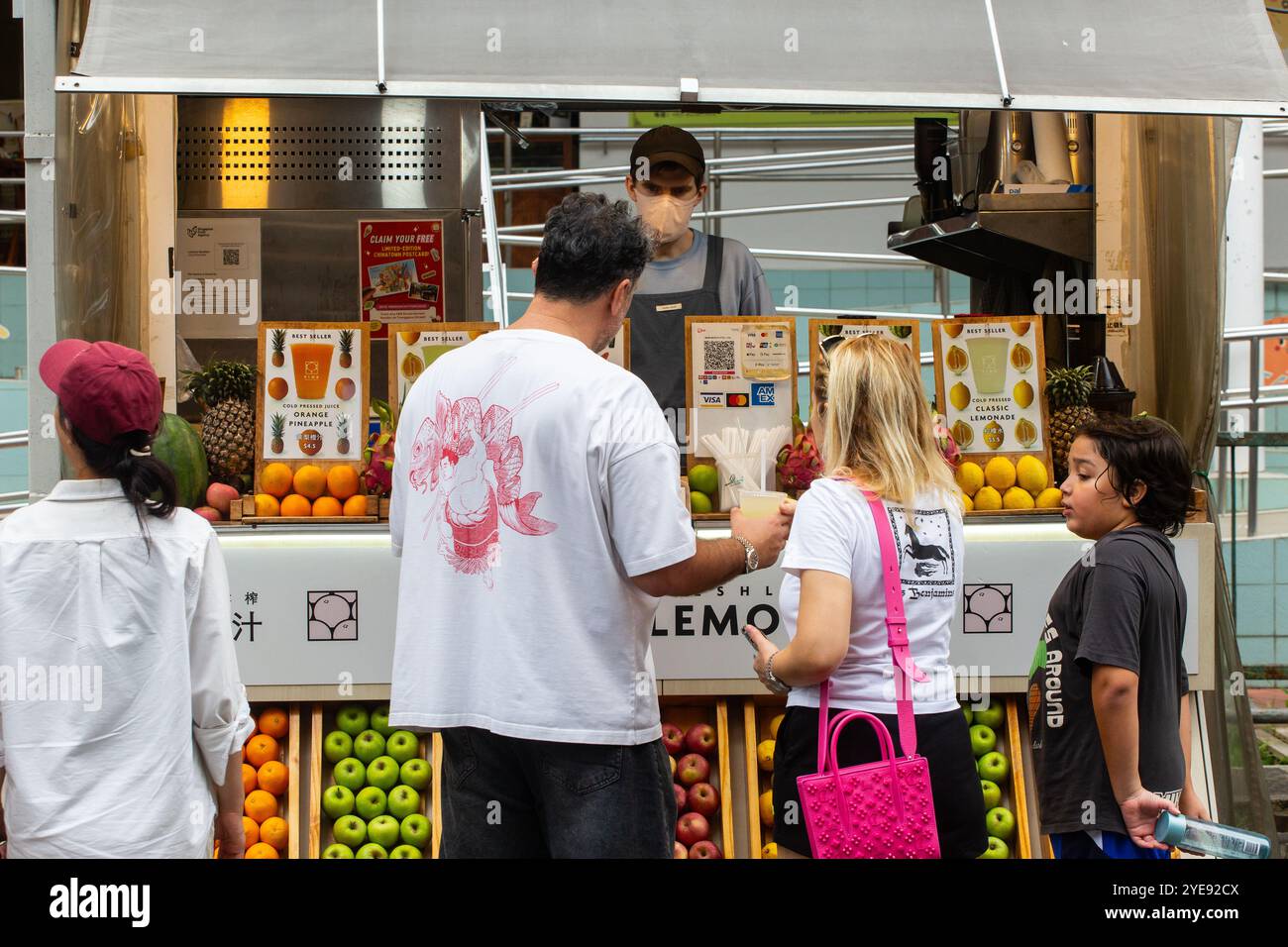 Tourists family buy fruit juice at a stall to quench thirst in the hot ...