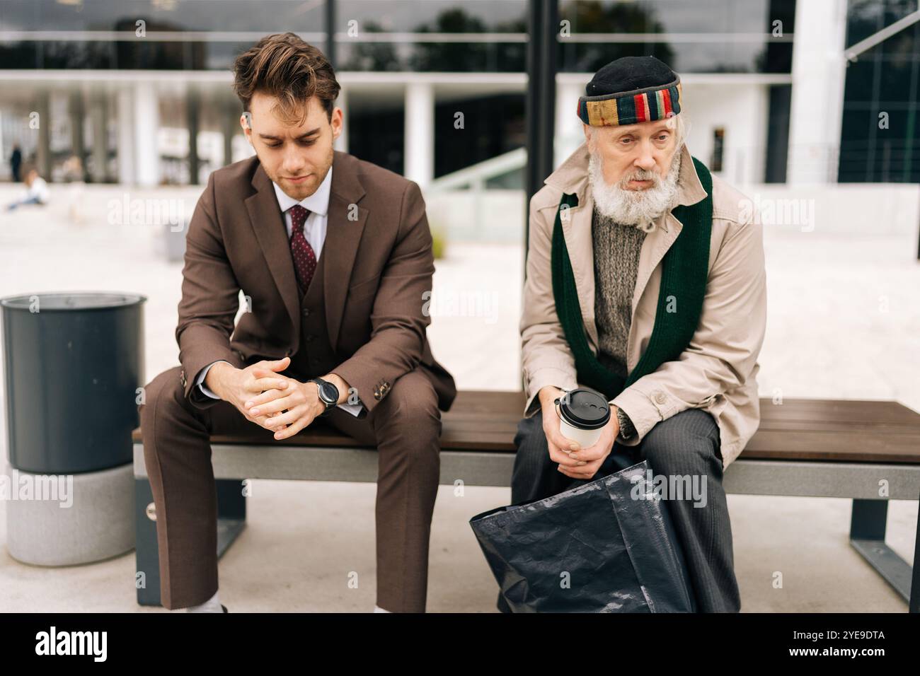 Portrait of communication young businessman and old homeless man ...